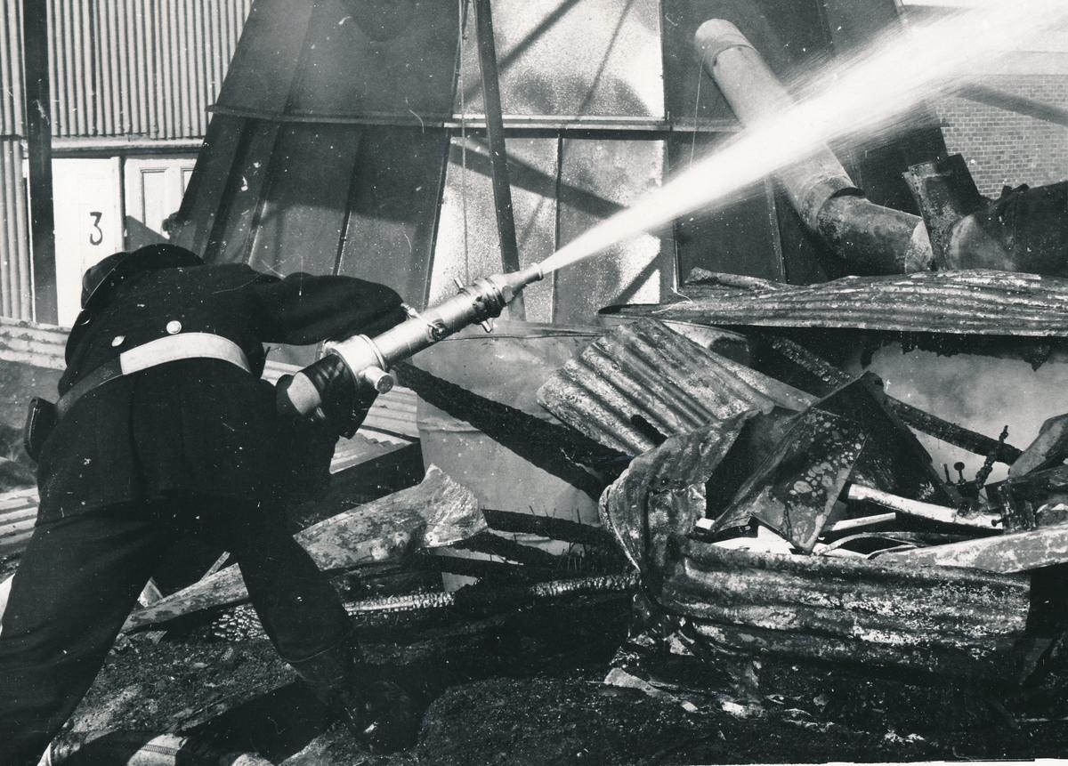 Fire fighting: 1958 fireman hosing burning building - Fletcher Trust ...